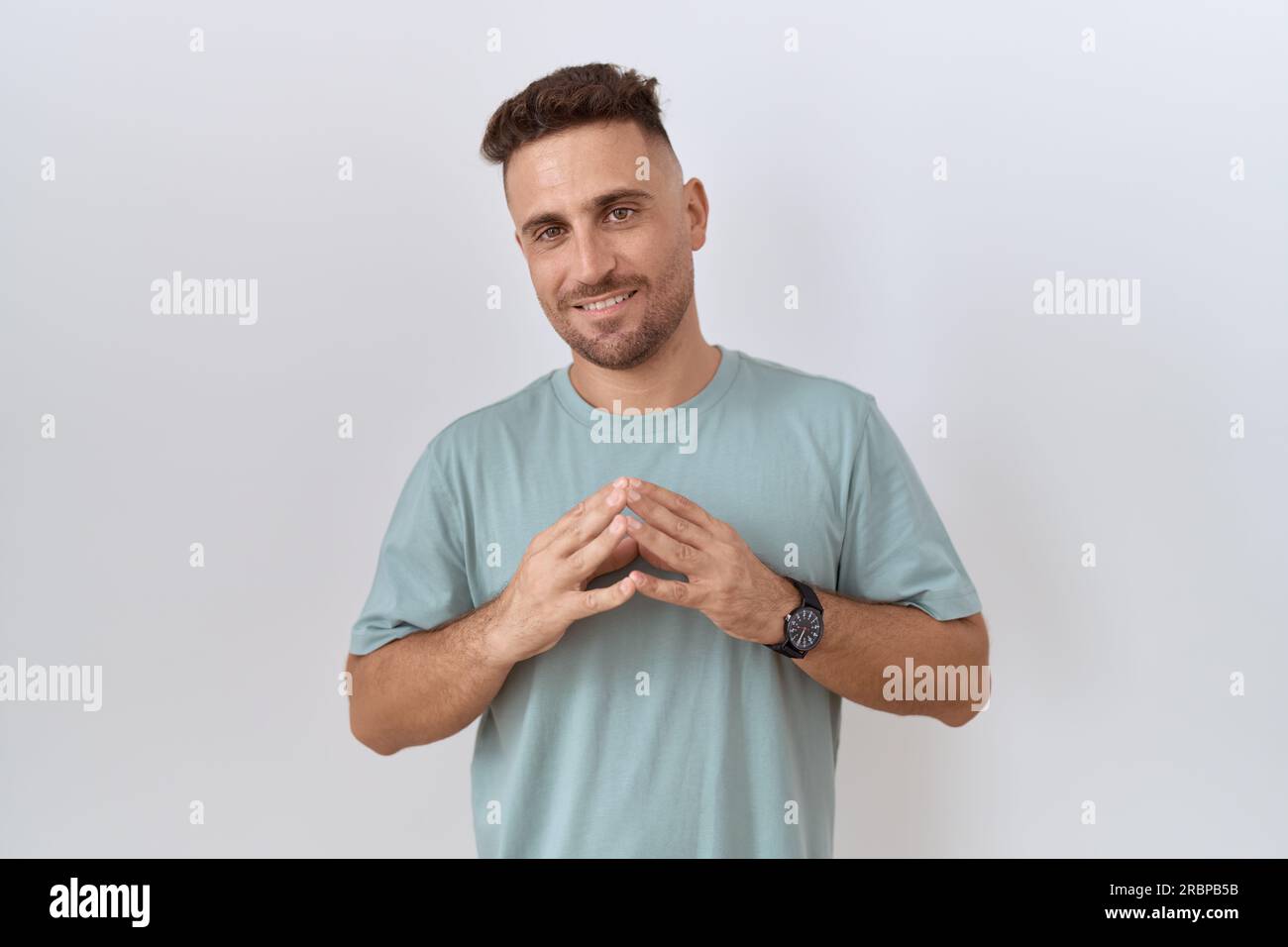 Hispanic man with beard standing over white background hands together ...