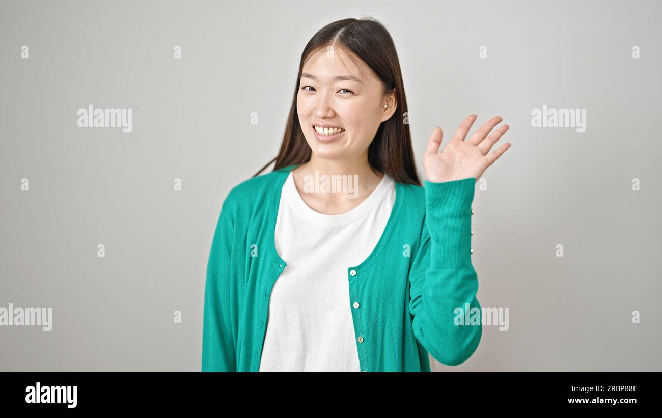 Young chinese woman smiling confident saying hello with hand over ...