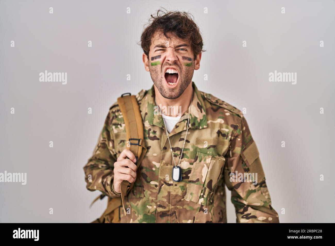 Hispanic young man wearing camouflage army uniform angry and mad ...