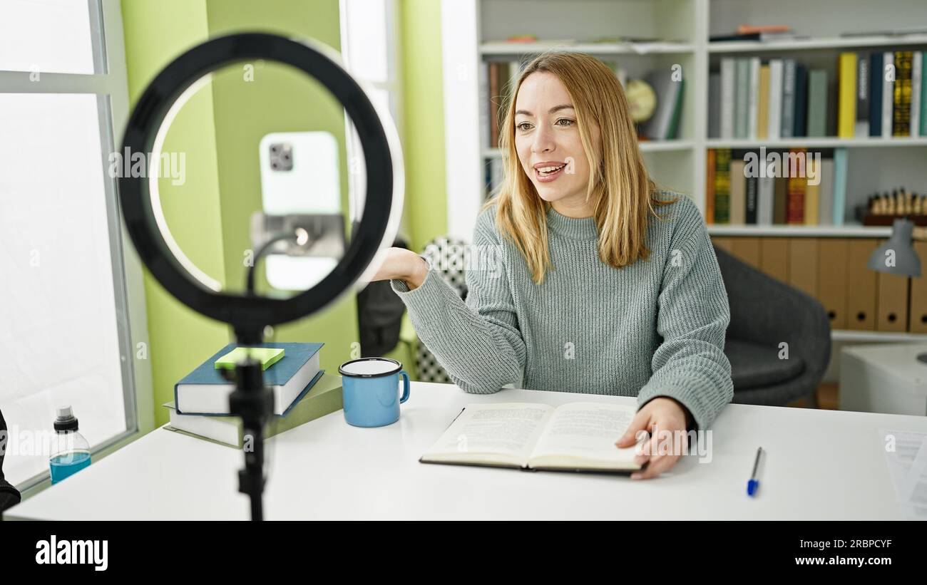 Young blonde woman student recording video tutorial at library ...