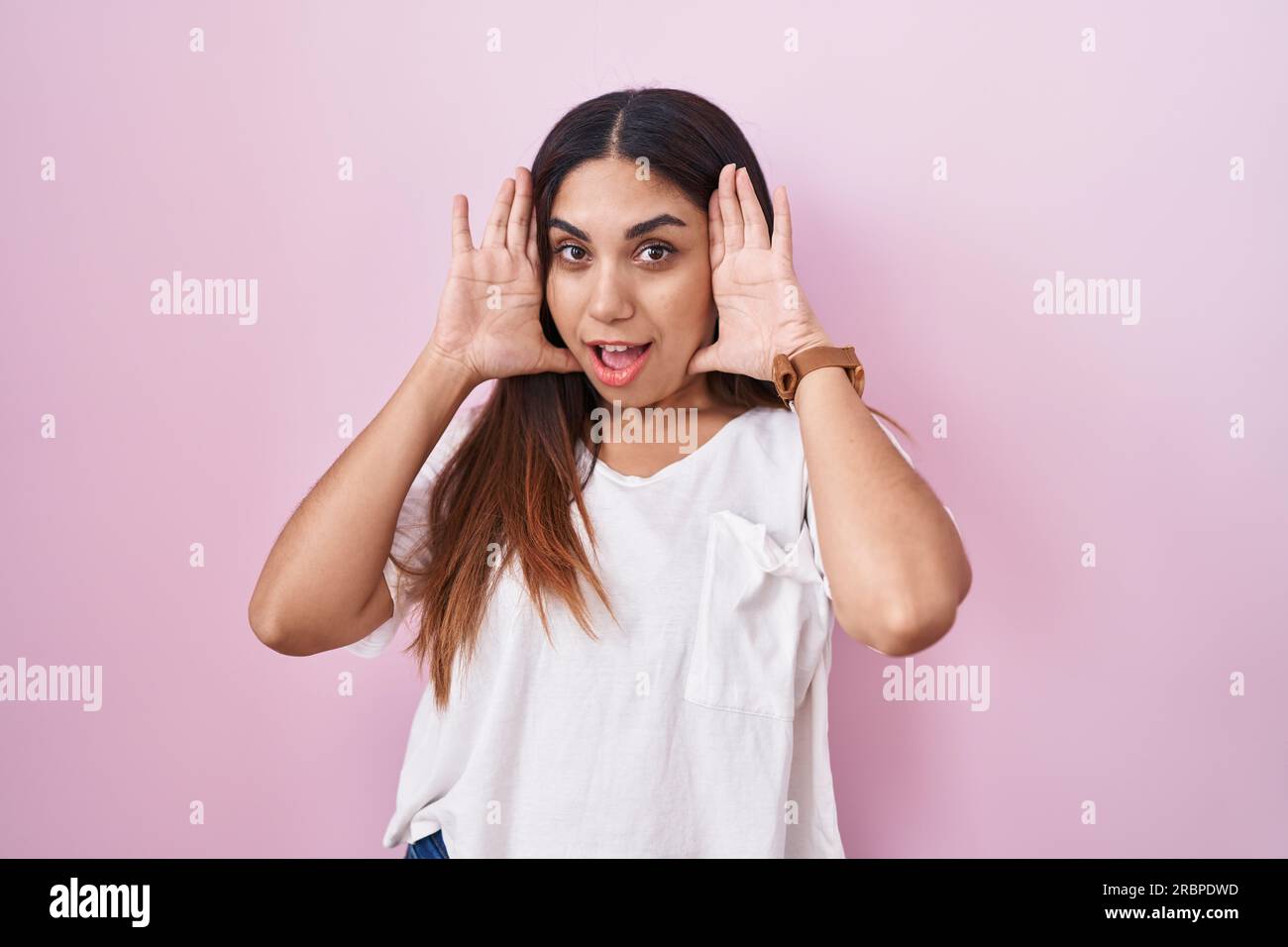 Young arab woman standing over pink background smiling cheerful playing ...