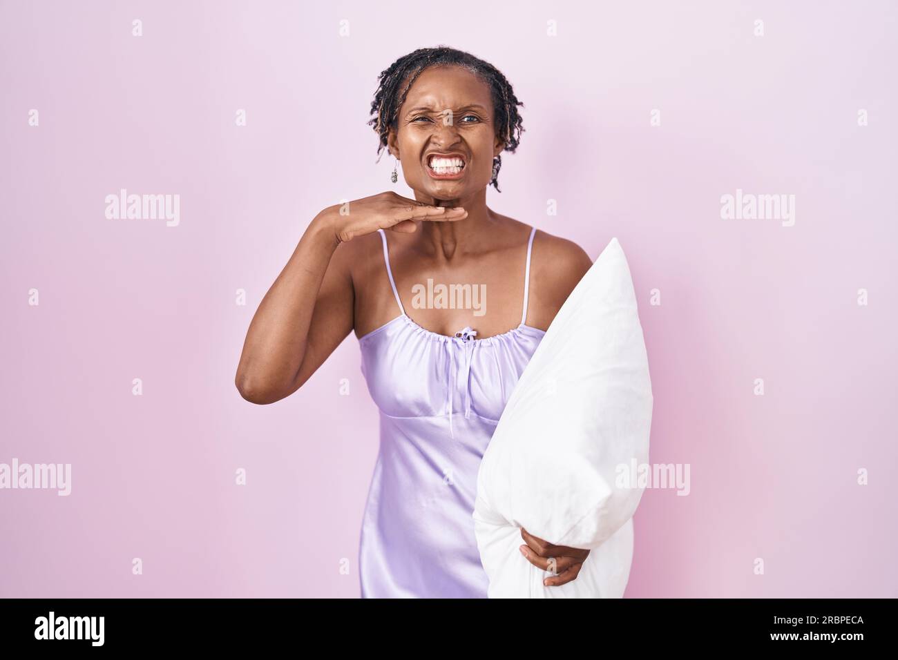 African Woman With Dreadlocks Wearing Pajama Hugging Pillow Cutting