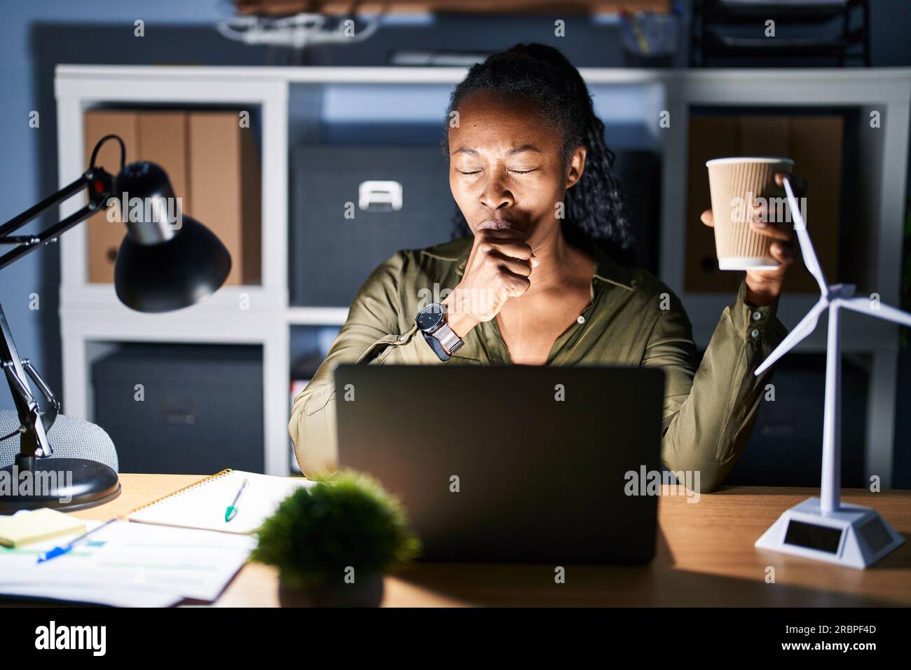 African woman working using computer laptop at night feeling unwell and ...