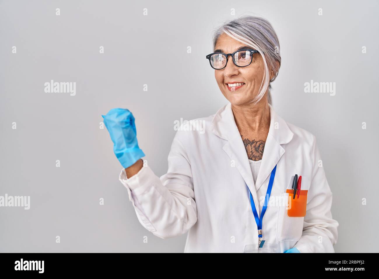 Middle age woman with grey hair wearing scientist robe smiling with ...