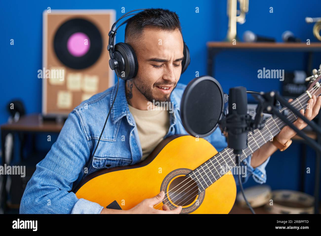 Young hispanic man artist singing song playing classical guitar at ...