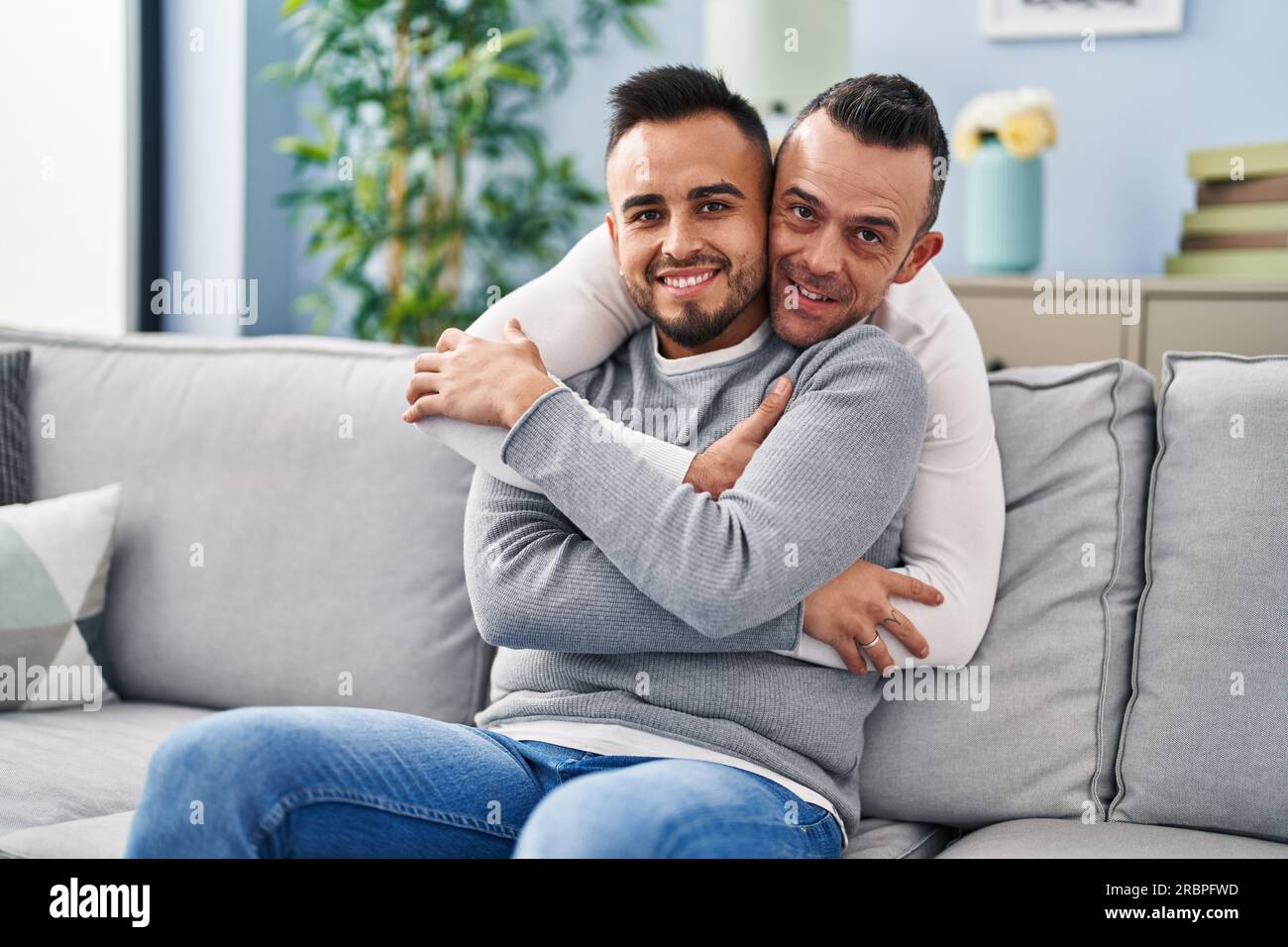 Two men couple hugging each other sitting on sofa at home Stock Photo ...