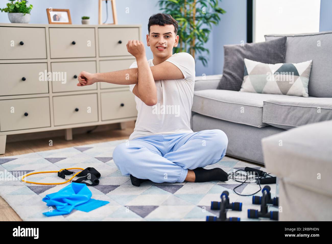 Young non binary man smiling confident stretching arms at home Stock ...
