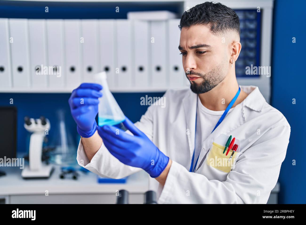 Young arab man scientist measuring liquid at laboratory Stock Photo - Alamy