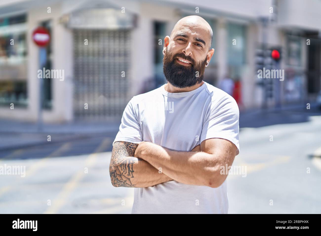 Young bald man standing with arms crossed gesture at street Stock Photo ...