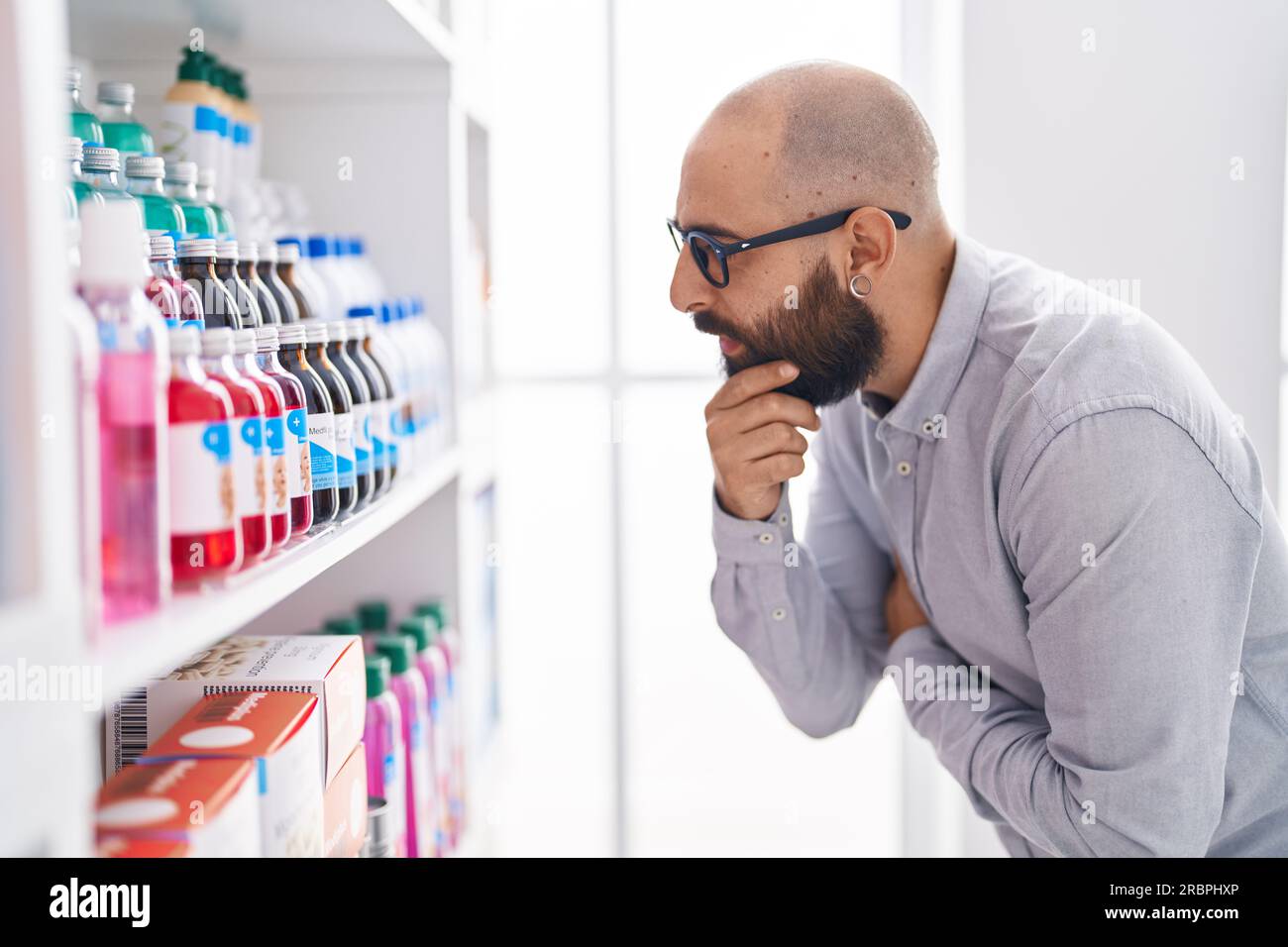 Young bald man customer looking shelving at street Stock Photo - Alamy