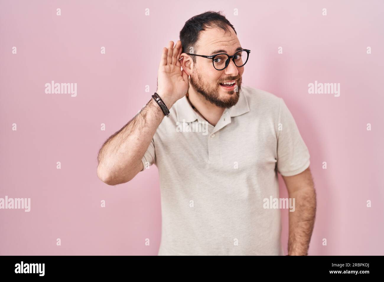Plus size hispanic man with beard standing over pink background smiling ...