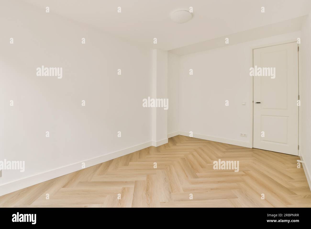 an empty room with white walls and parqueted wood floor in the middle ...
