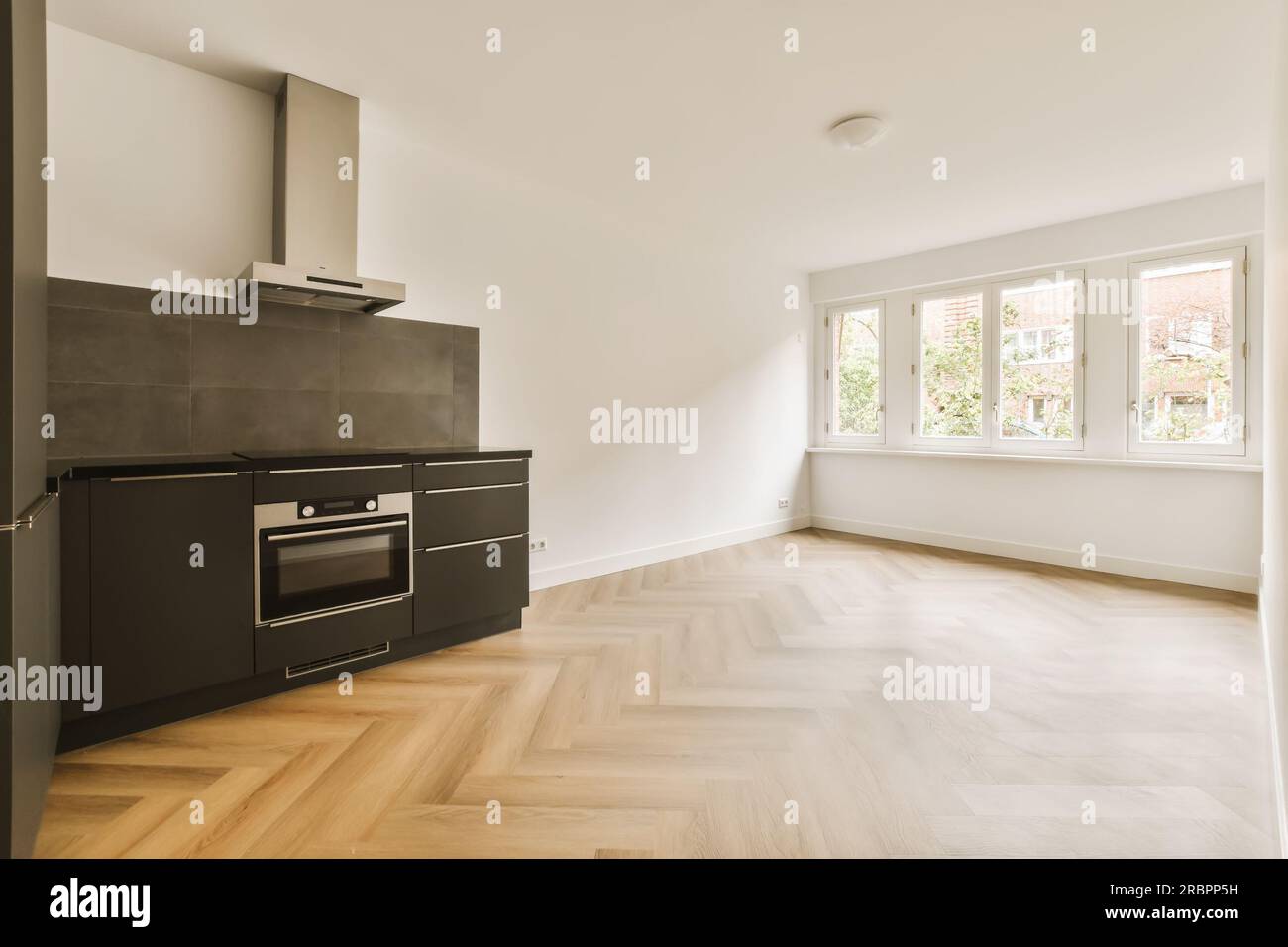 an empty kitchen with wood flooring and white walls in a room that has ...
