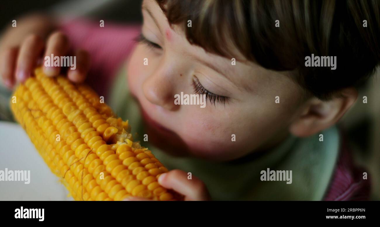 Kid eats corn one little boy eating food Stock Photo - Alamy