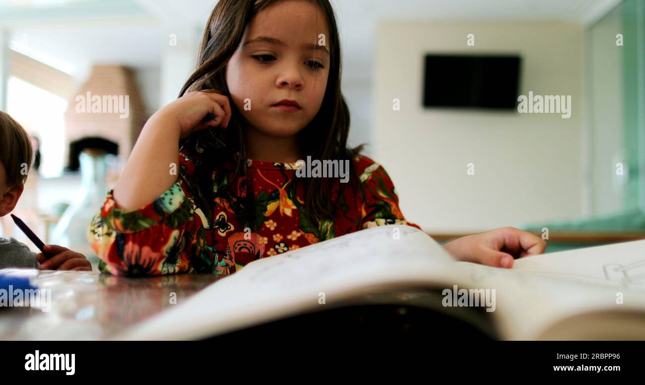 Little girl turning papers from drawing book child picking what page to ...