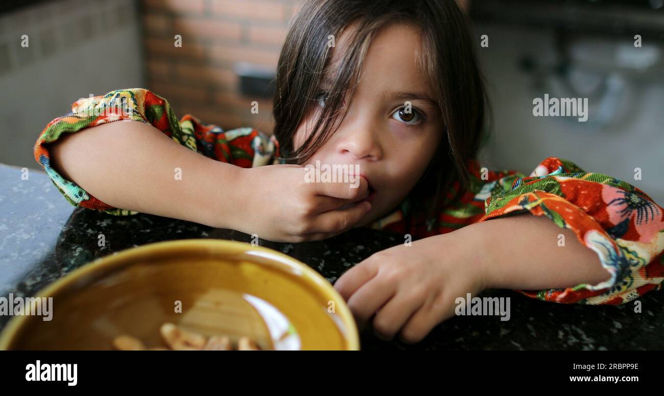 Little girl grabbing cashew nuts from bowl kid eating healthy snack ...