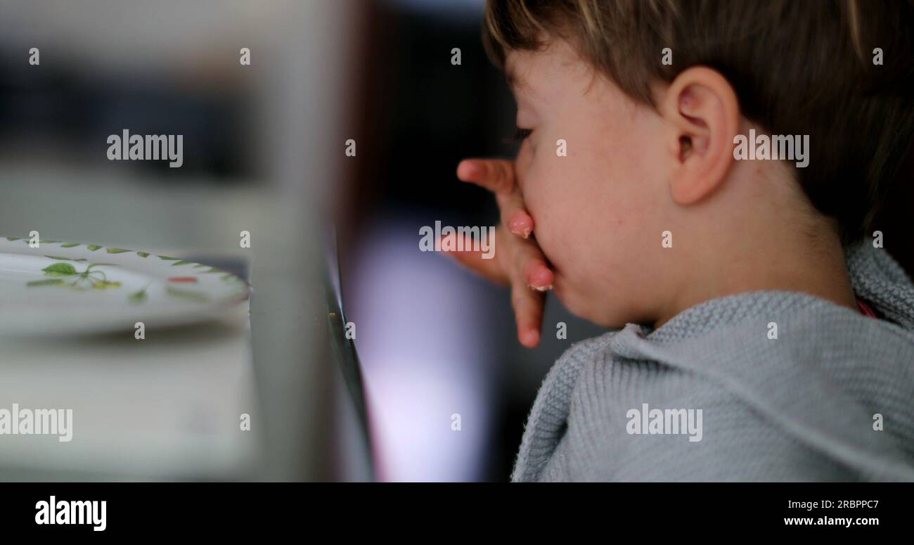 Child wiping mouth with hand kid rubbing face Stock Photo - Alamy