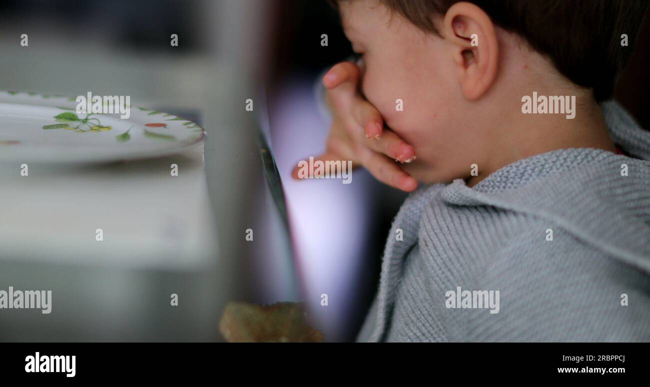 Child wiping mouth with hand kid rubbing face Stock Photo - Alamy