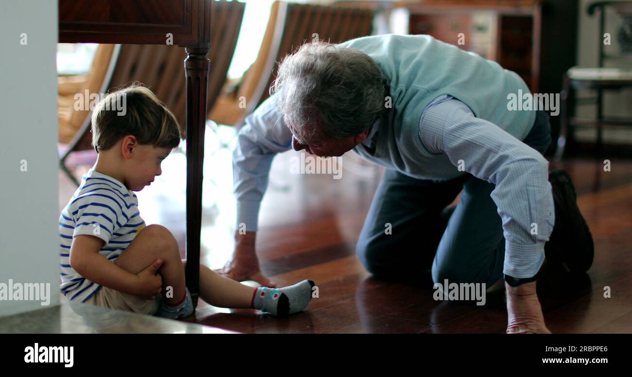 Empathic grandfather consoling hurt child grandparent reaching for ...