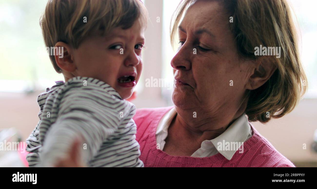 Grandmother consoling crying baby grandchild grandparent holding ...