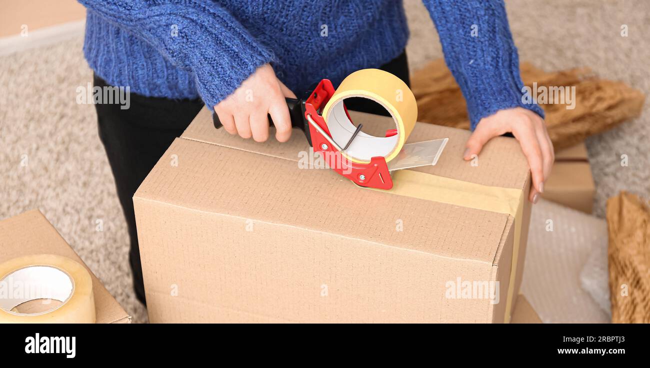 Woman packing cardboard box with adhesive tape dispenser Stock Photo ...