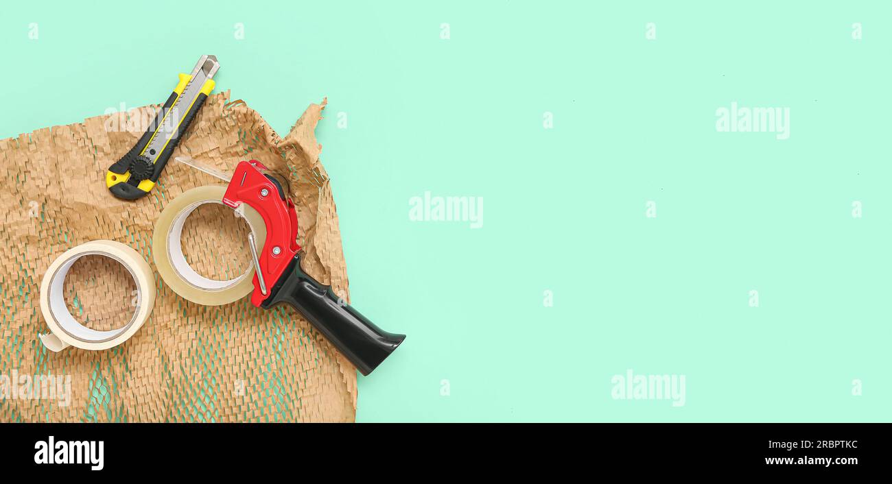 Adhesive tape rolls, dispenser, utility knife and wrapping paper on ...