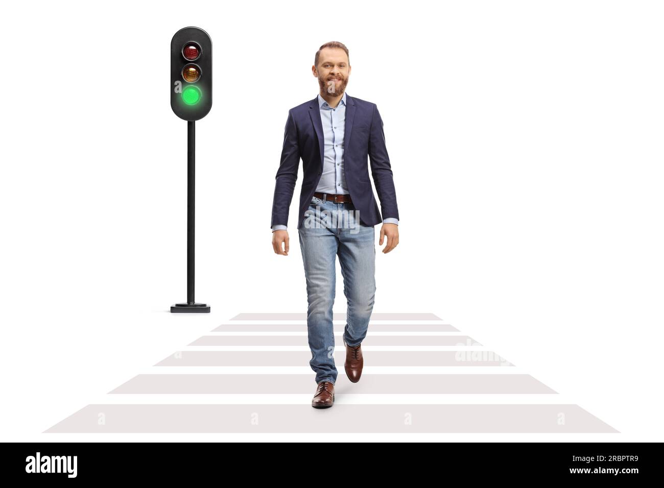 Full length portrait of a young smiling man crossing a street at green ...