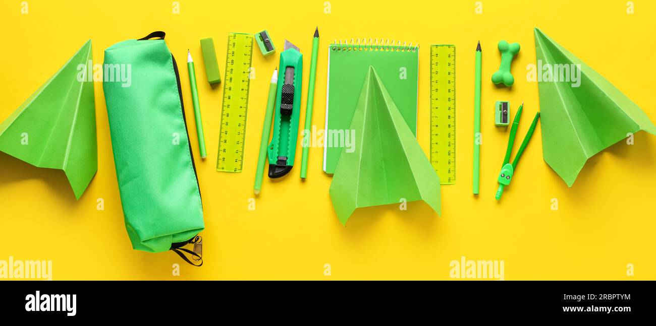 Green paper planes with school supplies on yellow background Stock ...
