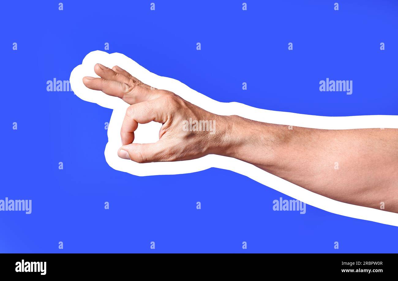 Male hand showing OK gesture on blue background Stock Photo - Alamy