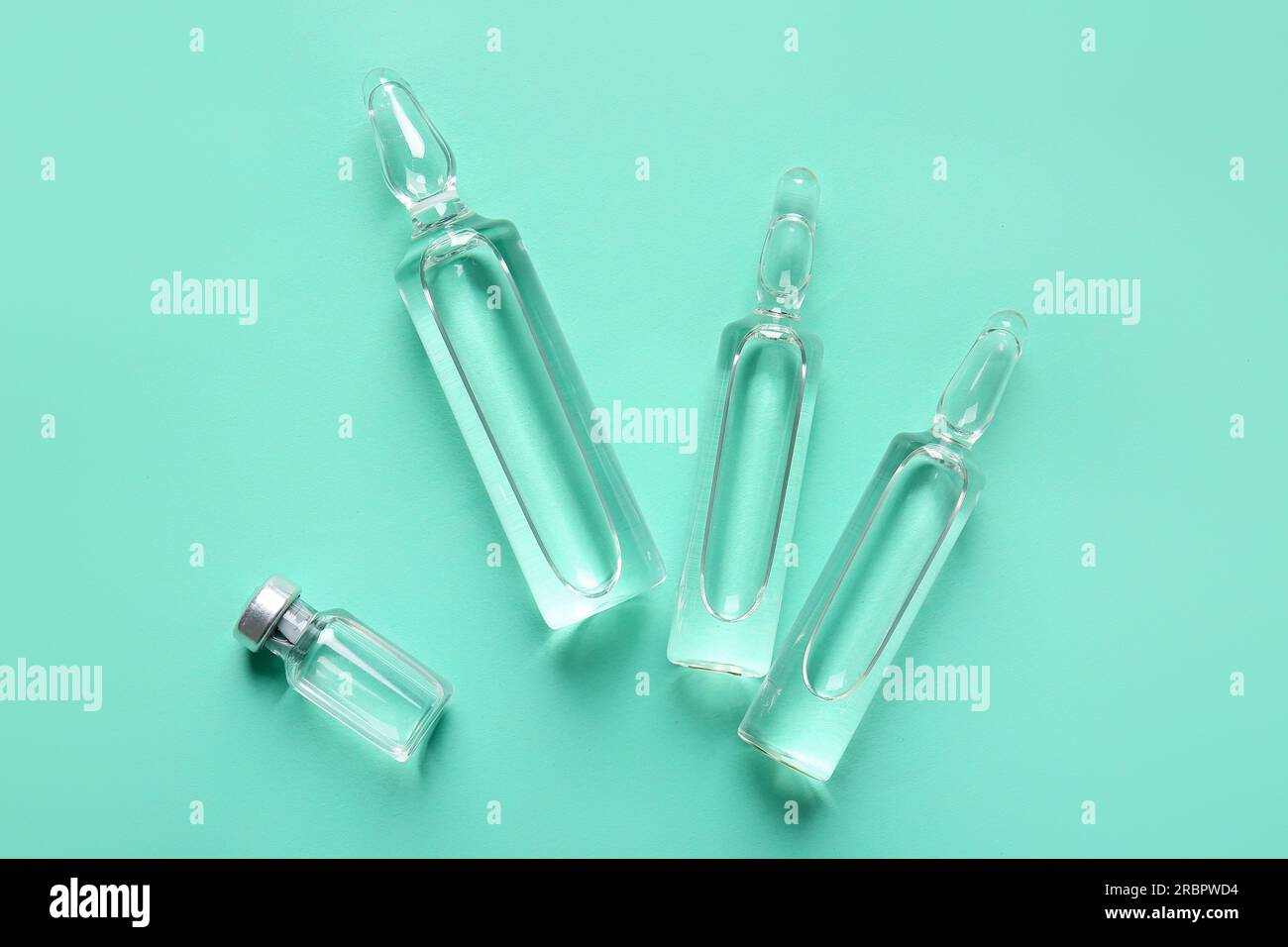 Medical ampules on green background Stock Photo - Alamy
