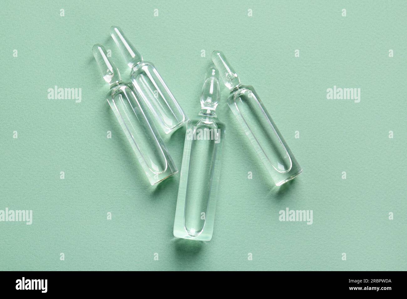 Medical ampules on green background Stock Photo - Alamy