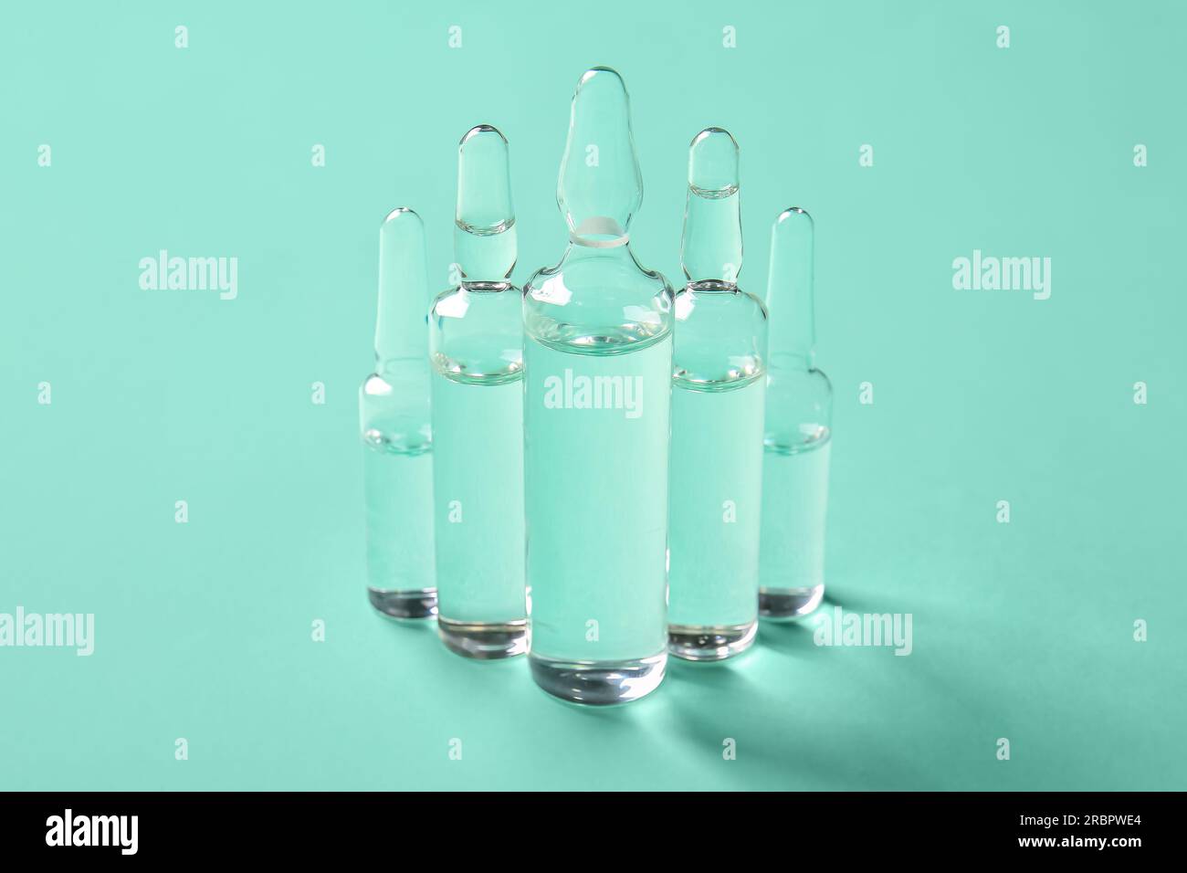 Medical ampules on green background Stock Photo - Alamy