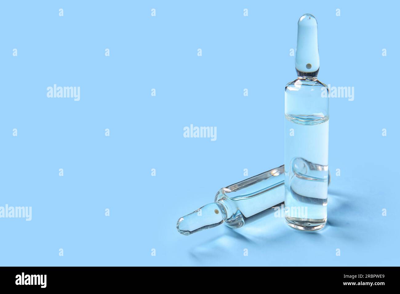 Medical ampules on blue background Stock Photo - Alamy