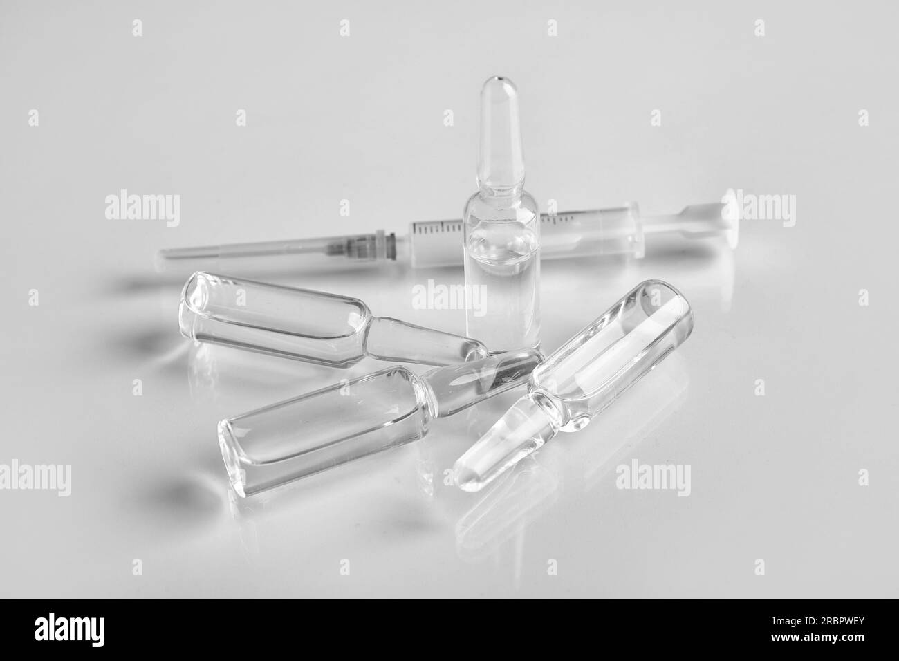 Medical ampules with syringe on light background Stock Photo - Alamy