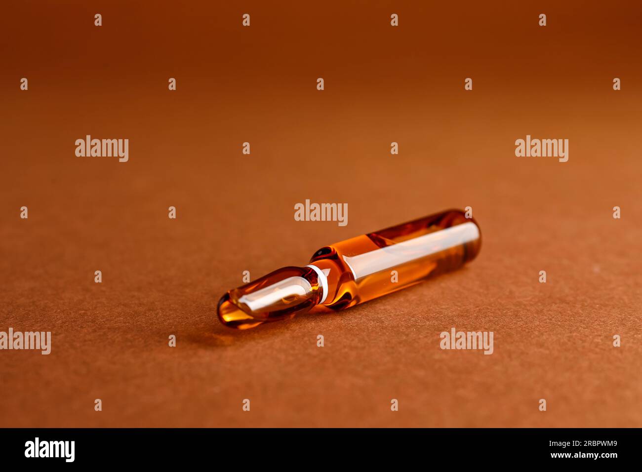 Glass ampule on brown background Stock Photo - Alamy