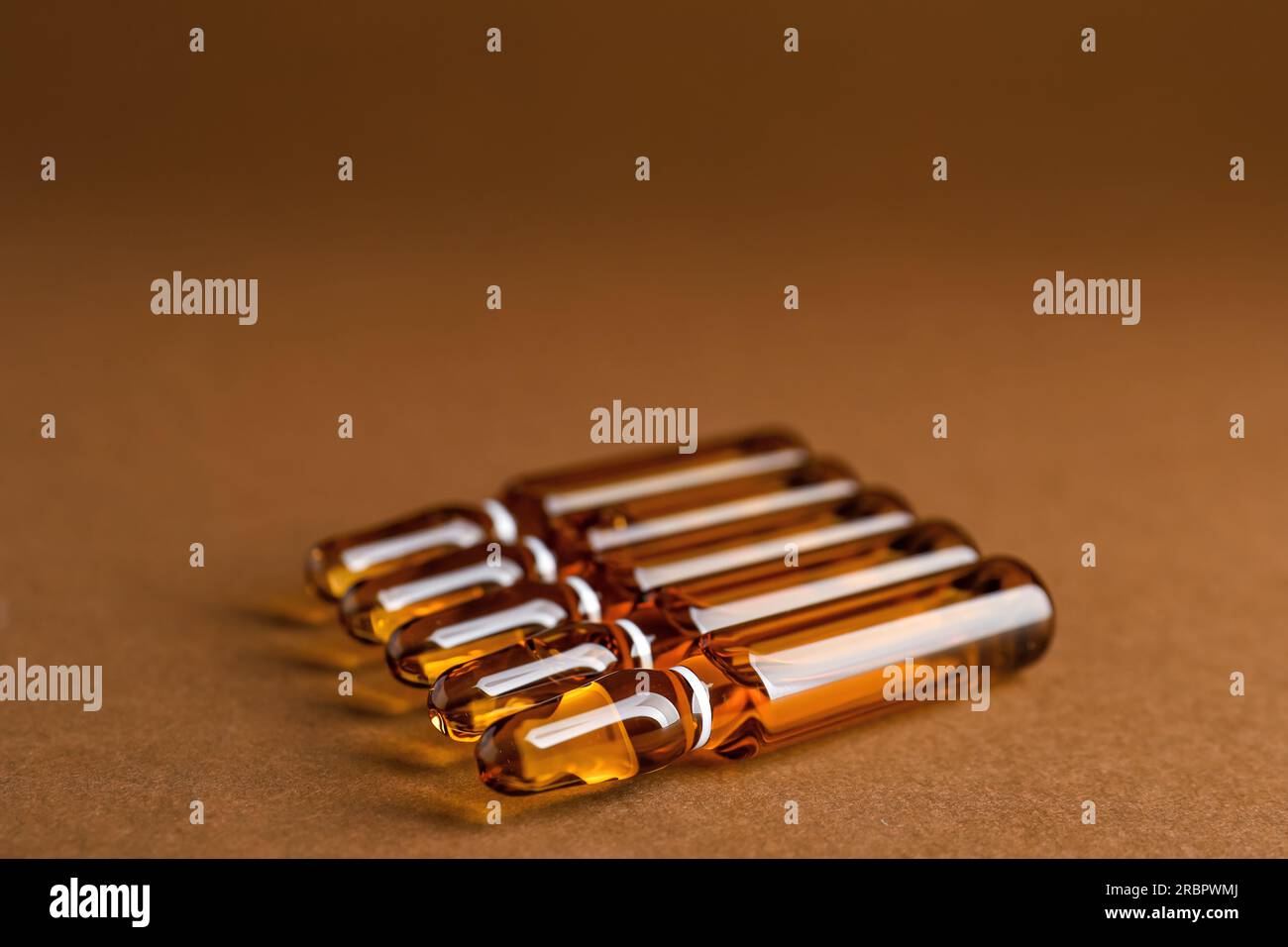 Glass ampules on brown background Stock Photo - Alamy