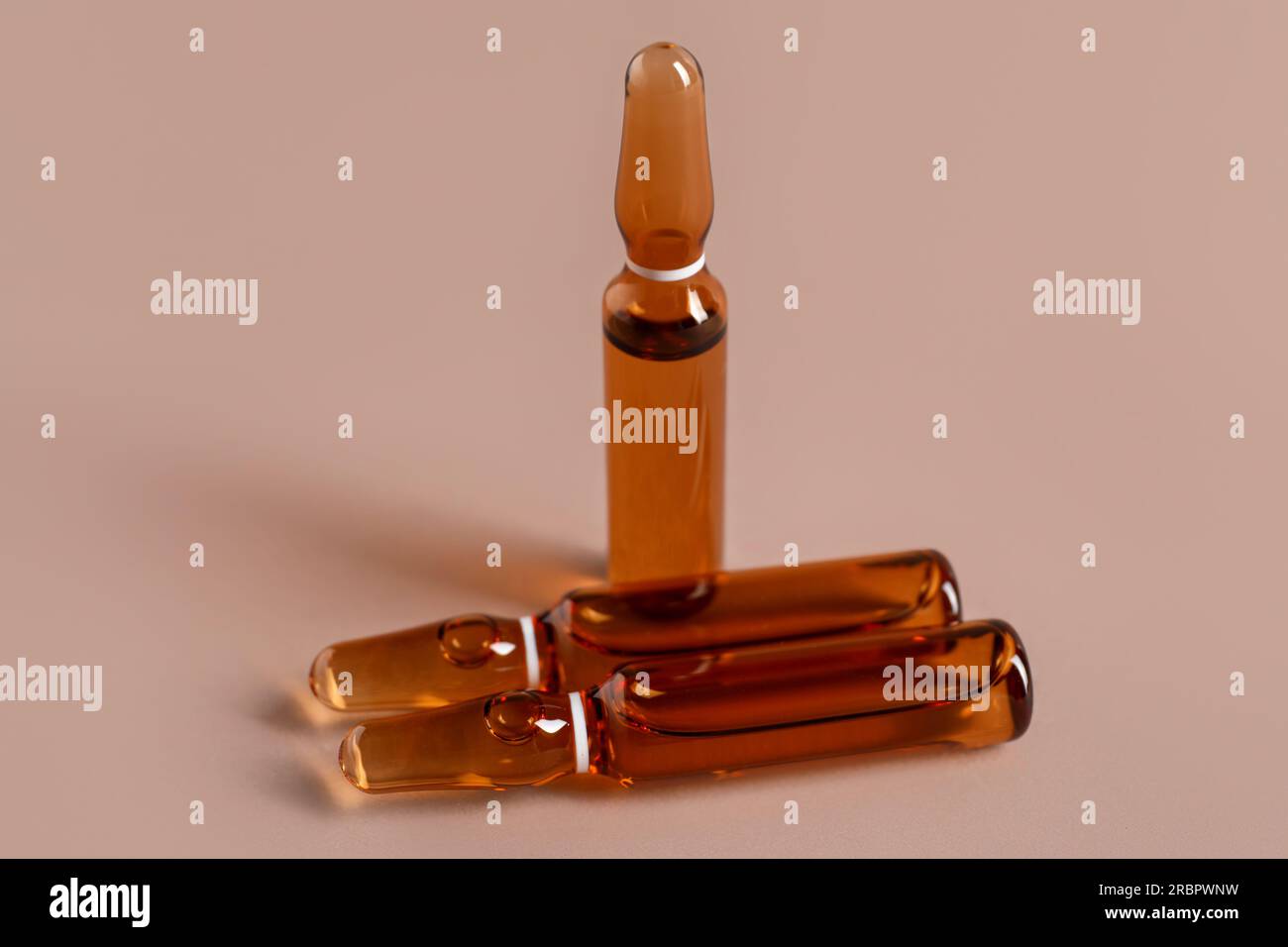 Glass ampules on brown background Stock Photo - Alamy