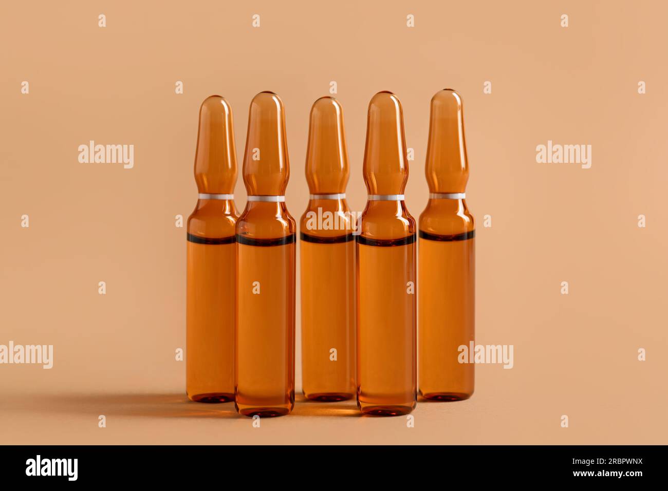 Glass ampules on brown background Stock Photo - Alamy