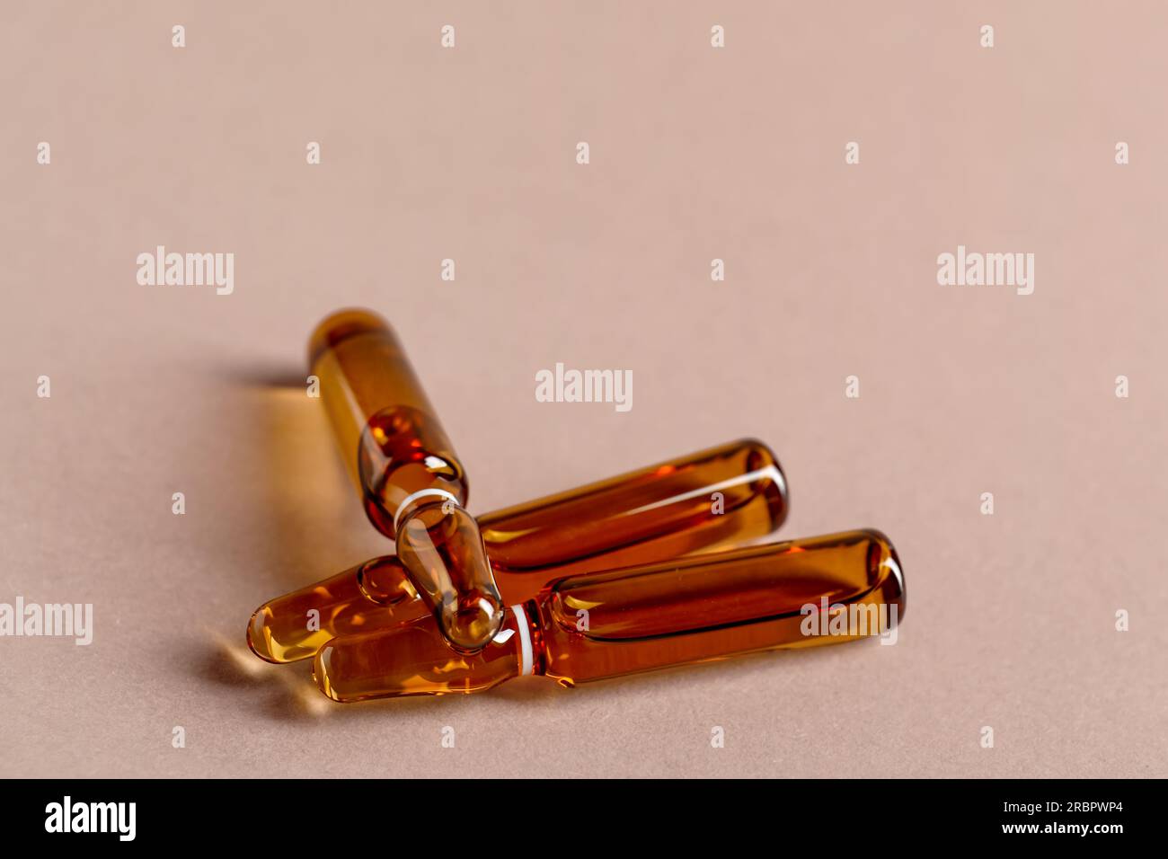 Glass ampules on brown background Stock Photo - Alamy