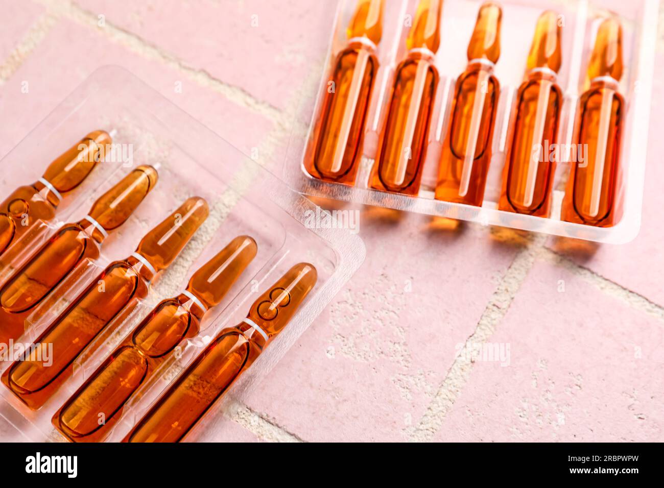 Medical ampules on pink tile background Stock Photo - Alamy