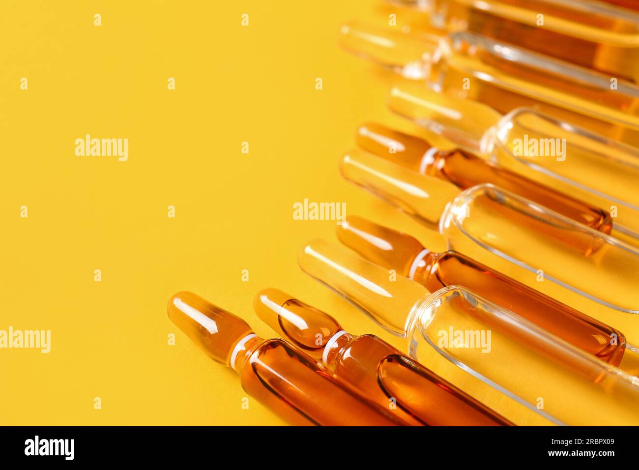 Glass medical ampules on yellow background Stock Photo - Alamy