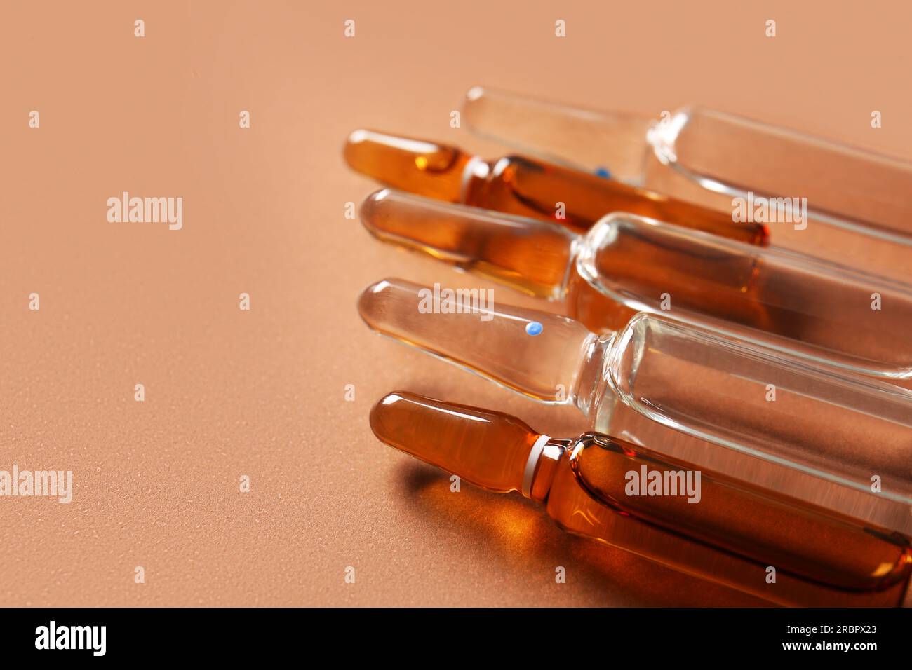 Glass medical ampules on brown background Stock Photo - Alamy