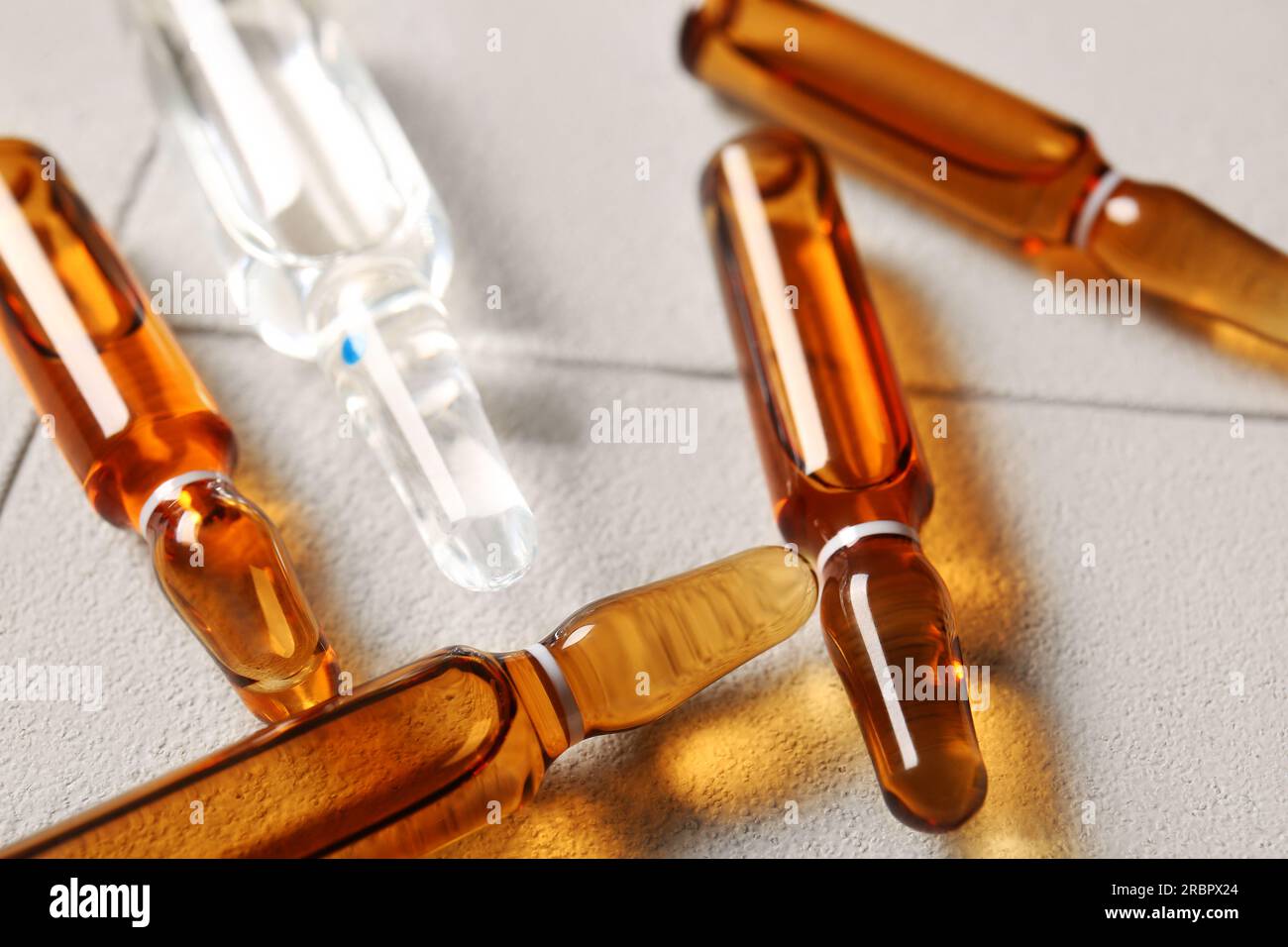 Glass medical ampules on white tile background Stock Photo - Alamy