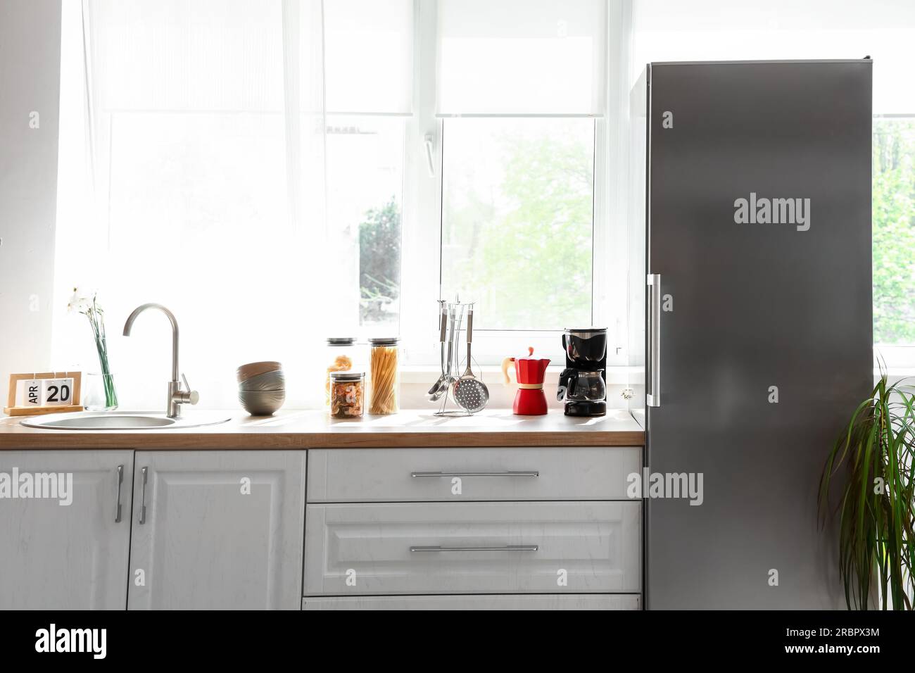 Interior of kitchen with stylish fridge, counters and window Stock ...