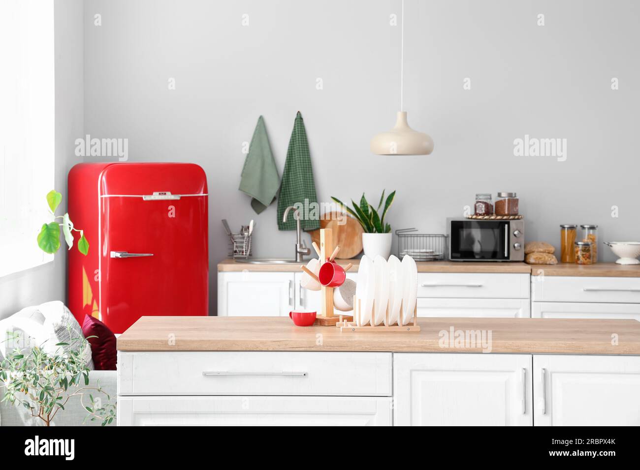 Interior of light kitchen with red fridge and counters Stock Photo - Alamy