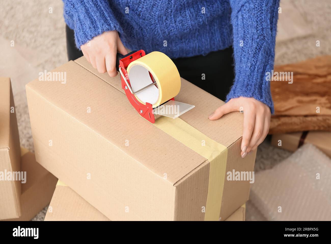 Woman packing cardboard box with adhesive tape dispenser Stock Photo ...