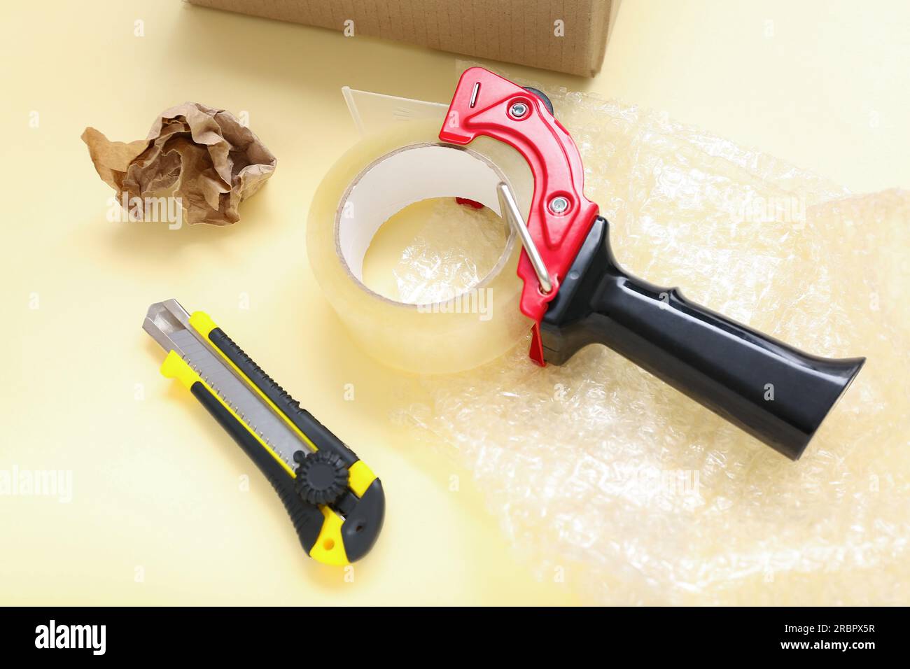 Packing tape dispenser, utility knife, bubble wrap and crumpled paper ...