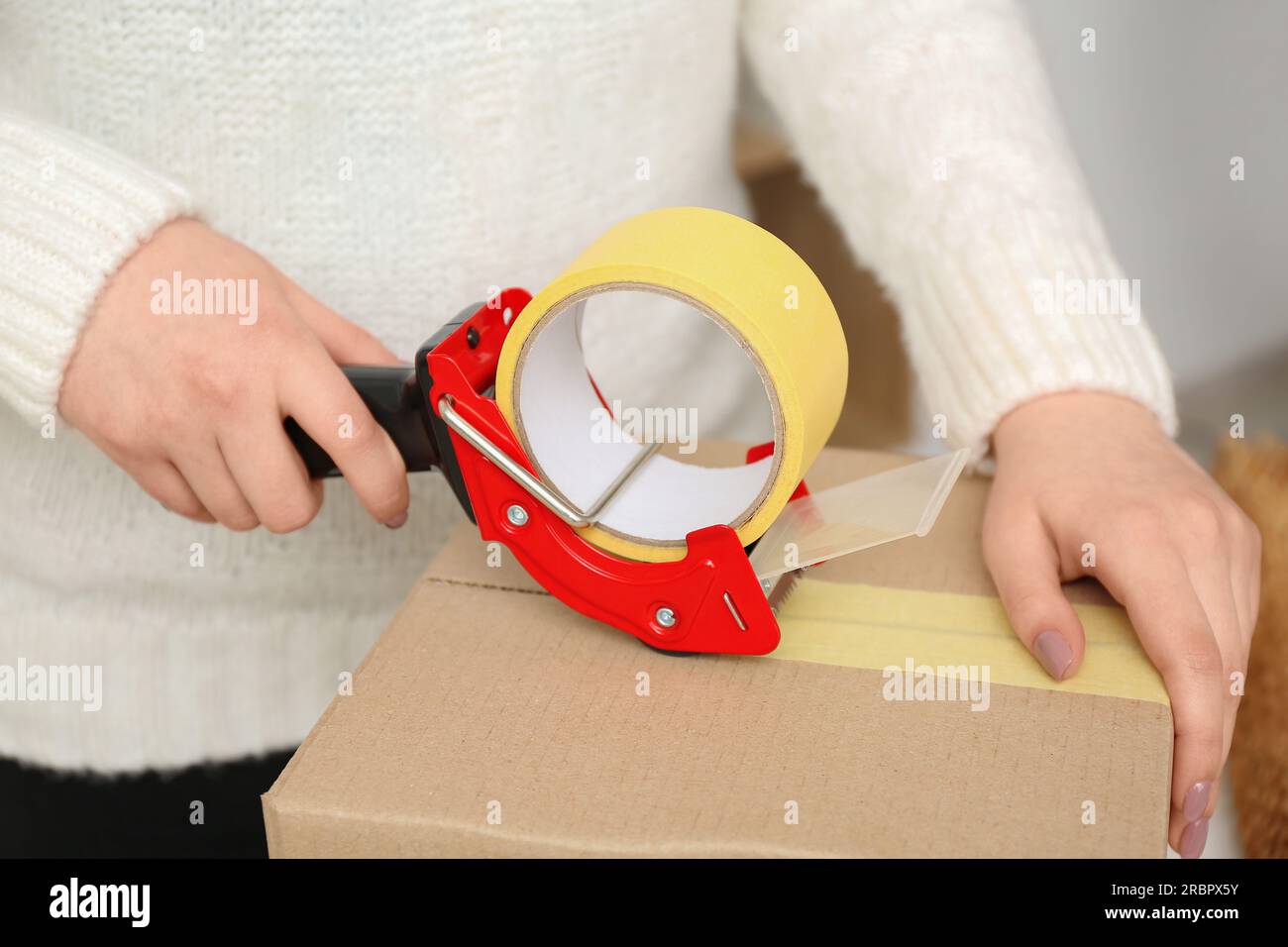 Woman packing cardboard box with adhesive tape dispenser Stock Photo ...