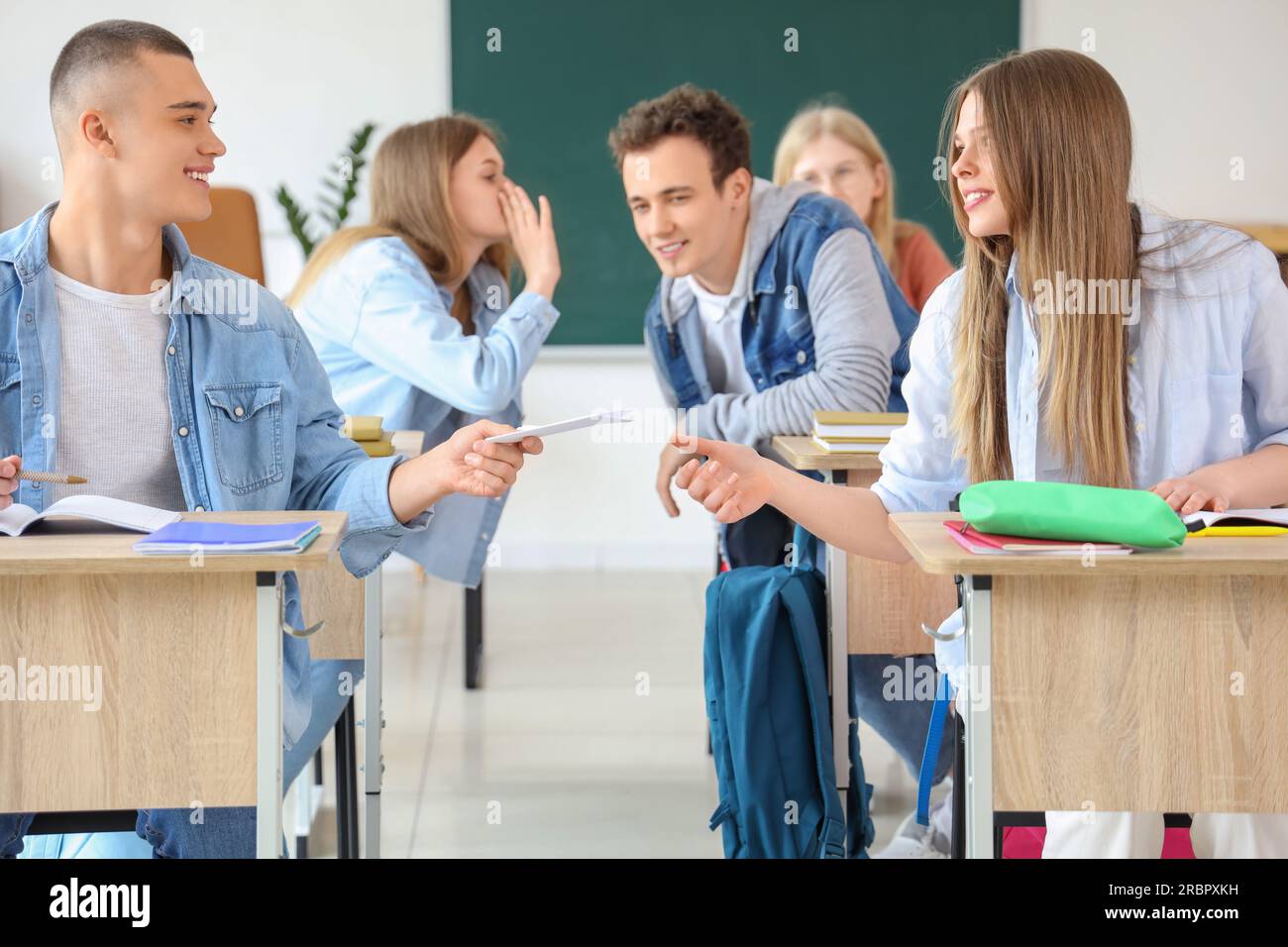 Students sitting and gossiping with his classmates in classroom Stock ...