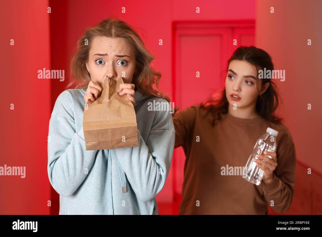 Woman giving water to girl who is having panic attack Stock Photo - Alamy